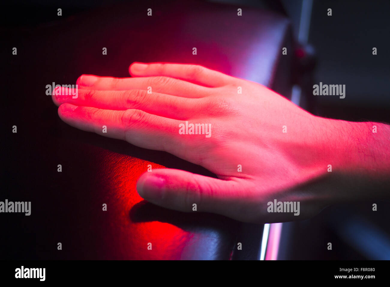 Patient hand in red physiotherapy heat treatment under hot light Stock ...