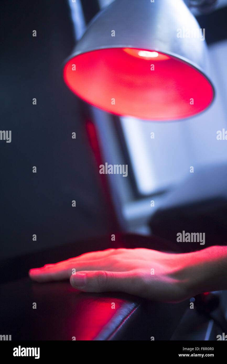 Patient hand in red physiotherapy heat treatment under hot light Stock ...