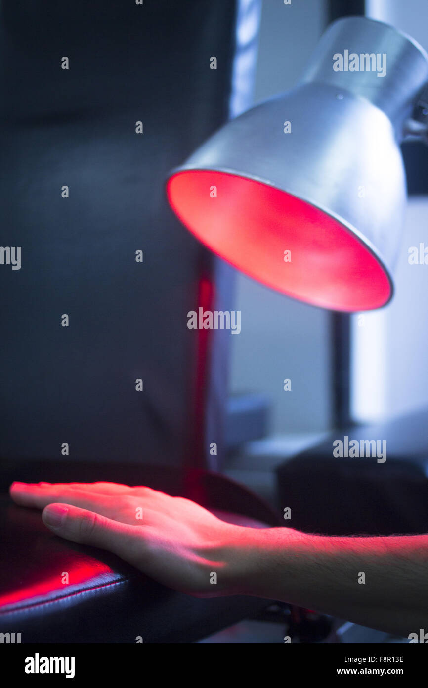 Patient hand in red physiotherapy heat treatment under hot light Stock ...