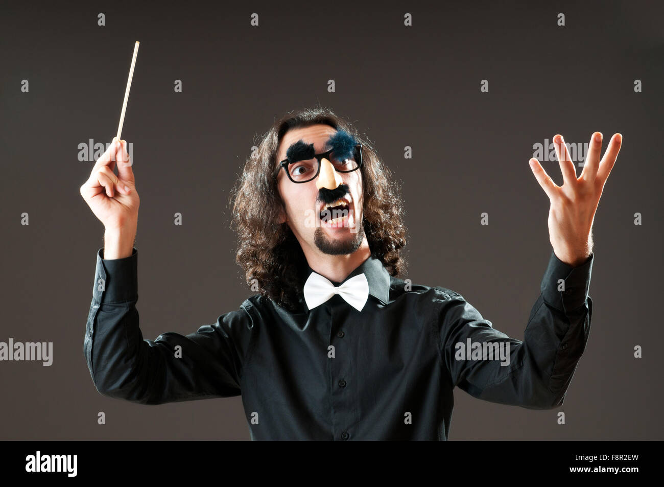 Funny conductor against dark background Stock Photo - Alamy
