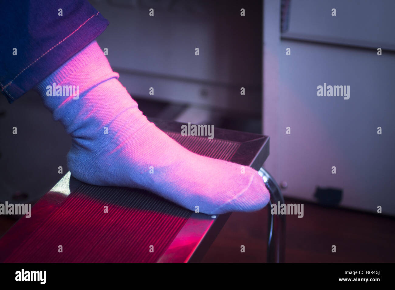 Patient foot in red physiotherapy heat treatment under hot light Stock ...