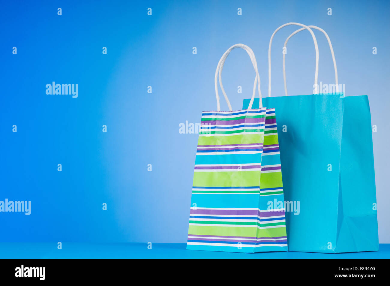 Colourful paper shopping bags against gradient background Stock Photo ...