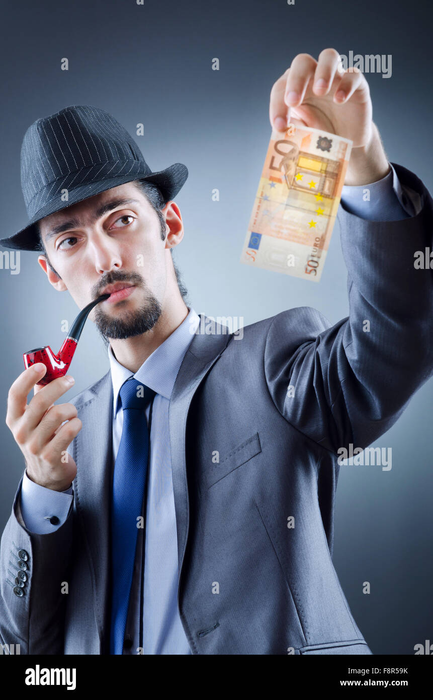 Detective looking at fake money Stock Photo - Alamy