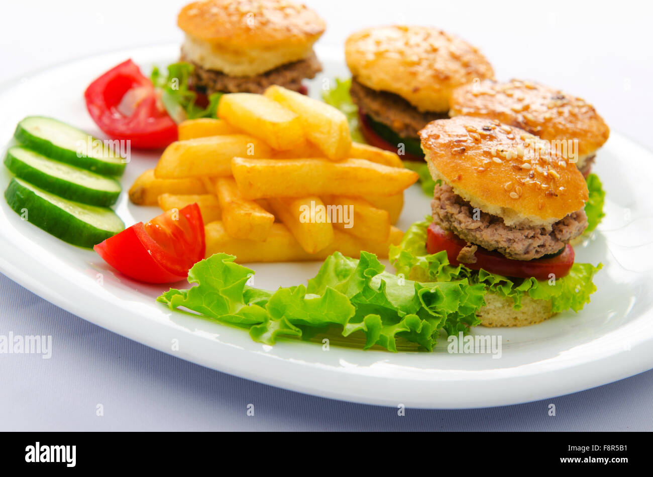 Plate with tasty mini burgers Stock Photo - Alamy