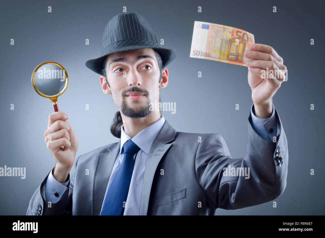 Detective looking at fake money Stock Photo - Alamy