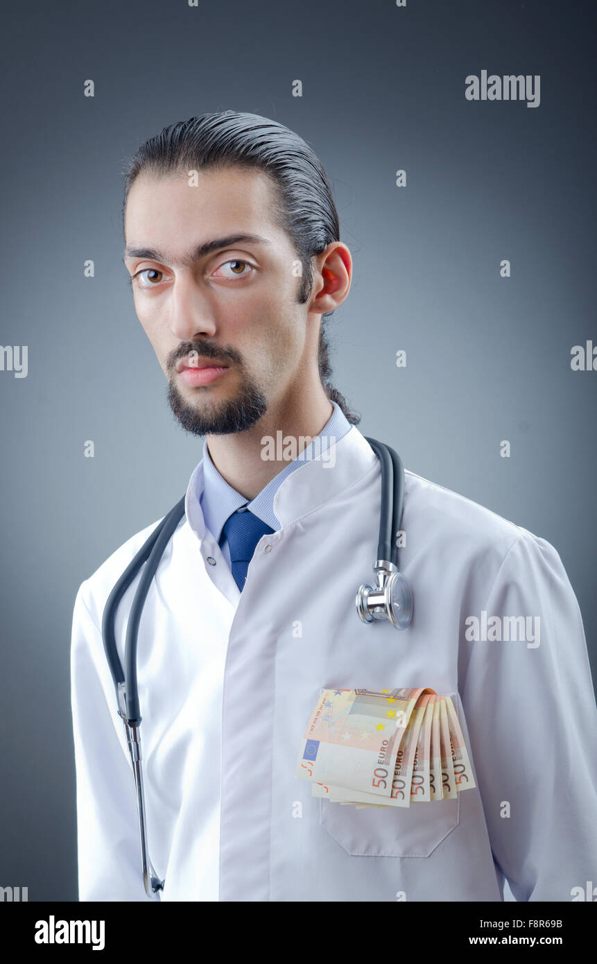 Doctor with money in studio Stock Photo - Alamy