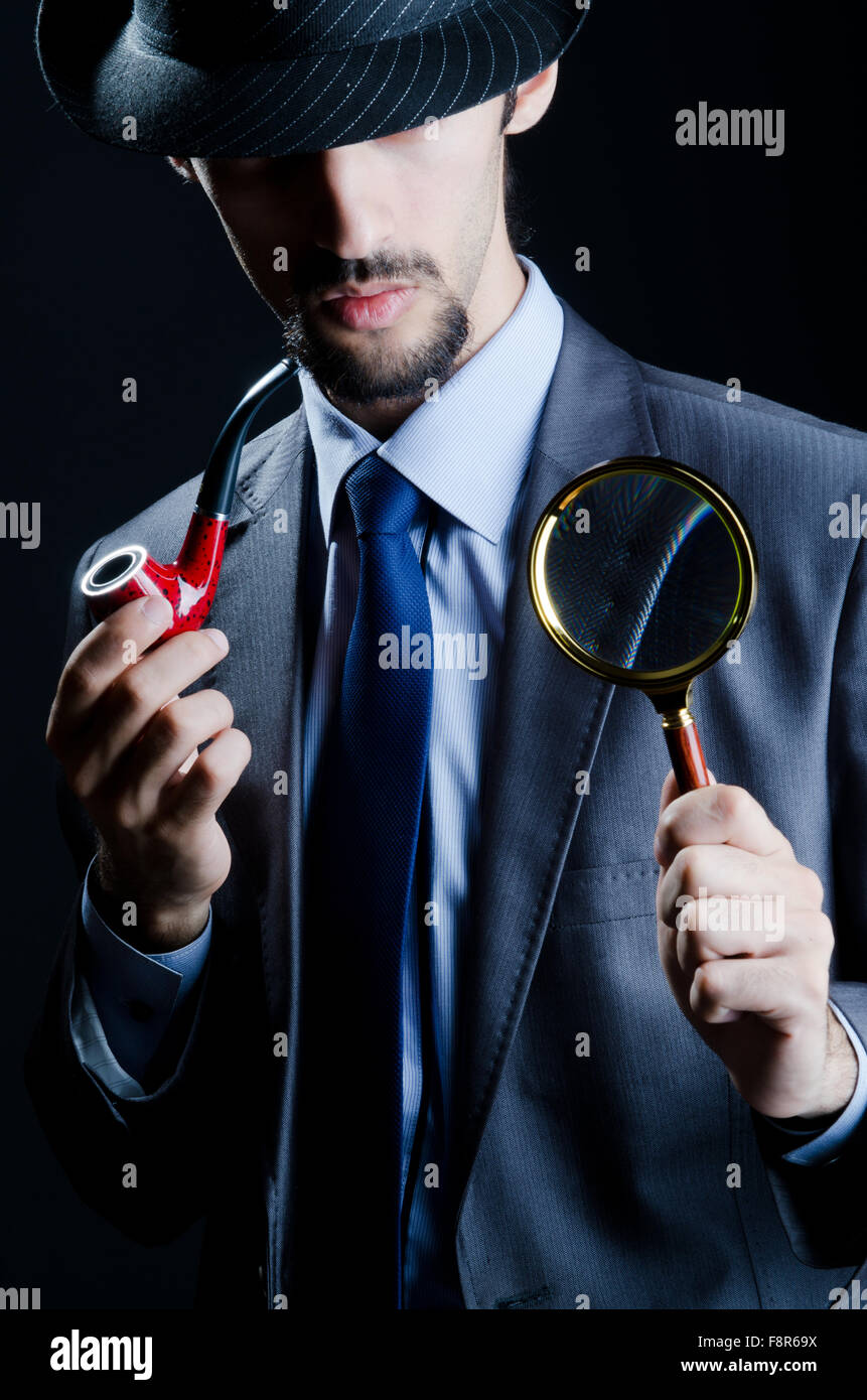 Detective with magnifying glass and pipe Stock Photo - Alamy