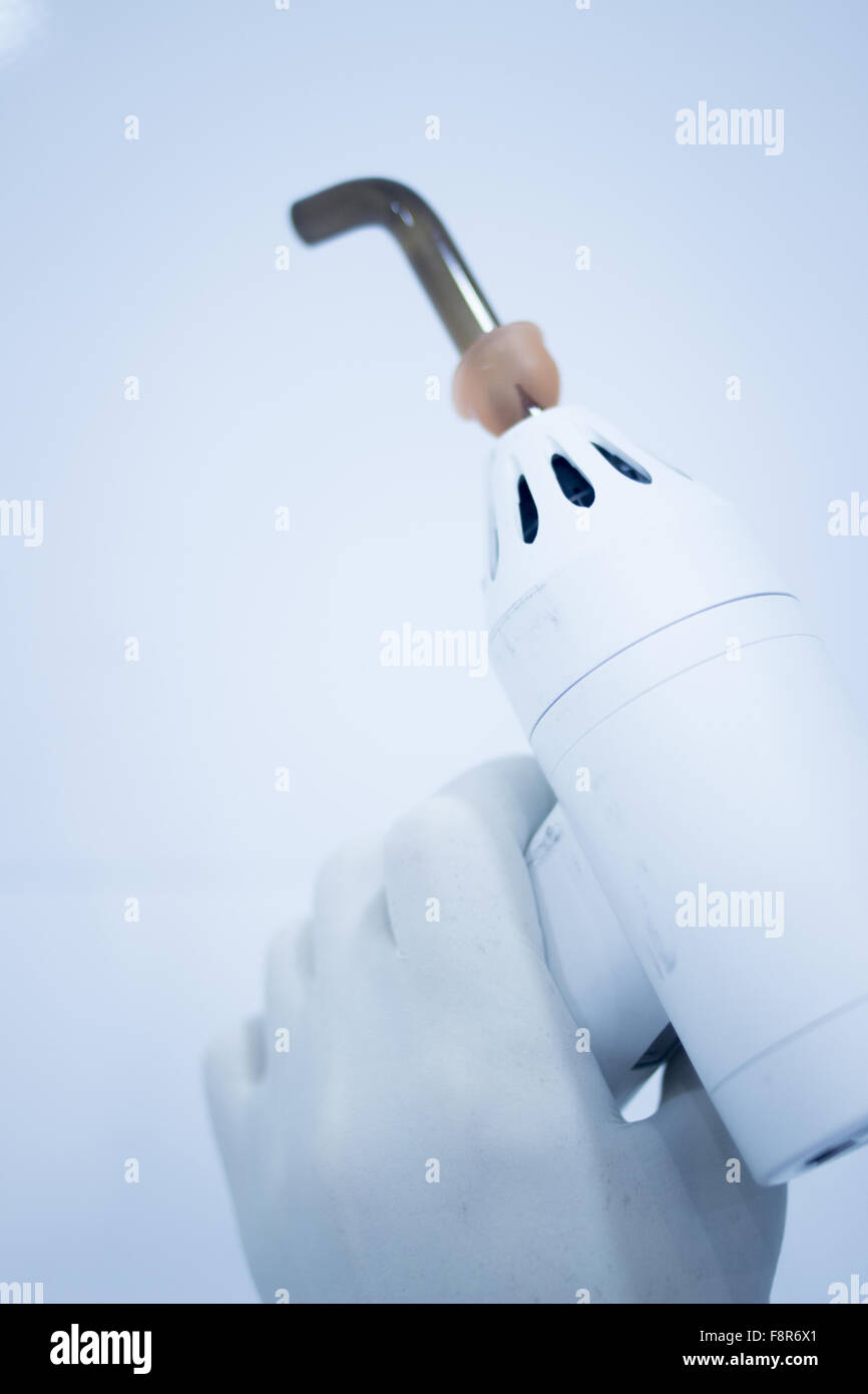 Dental filling gun in dentist hand in clinic office surgery used to ...