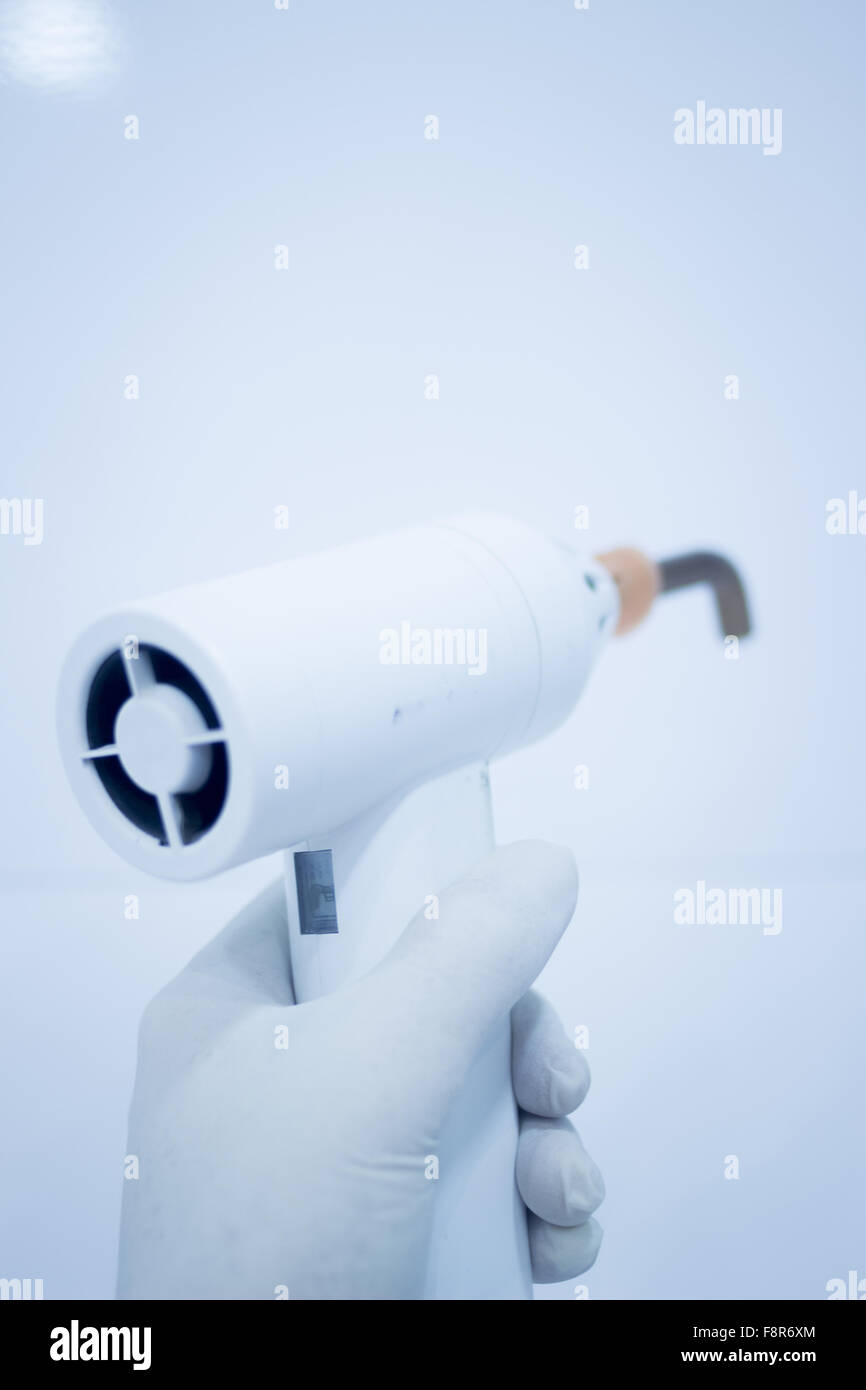 Dental filling gun in dentist hand in clinic office surgery used to ...