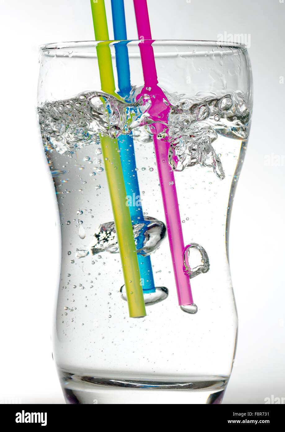 Glass of water with bubbles and colorful straws Stock Photo - Alamy