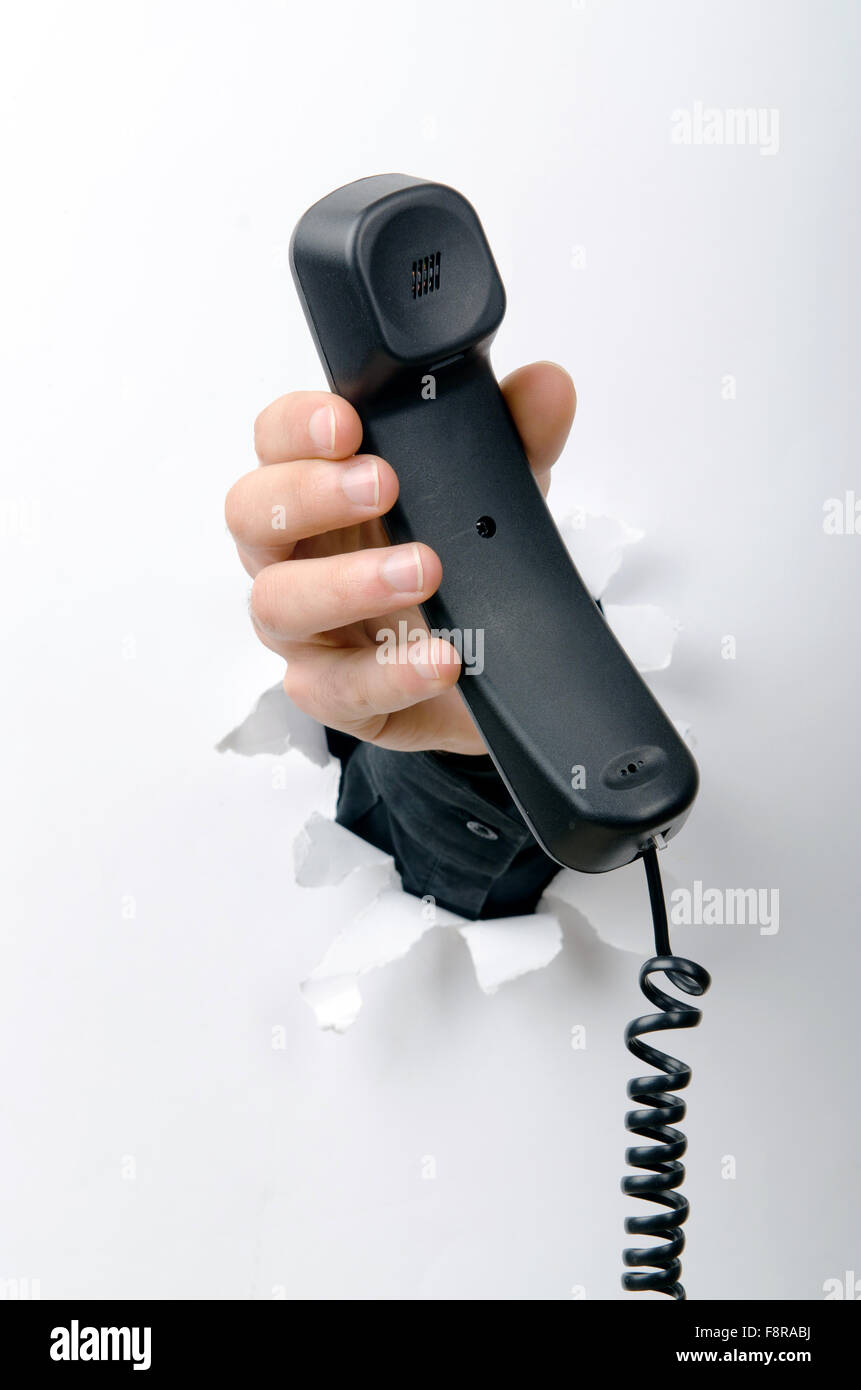 Hand holding phone through hole in paper Stock Photo - Alamy
