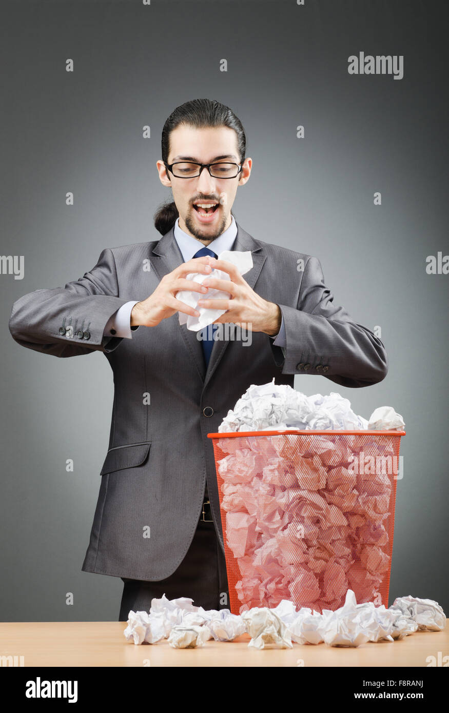 Man with lots of wasted paper Stock Photo - Alamy