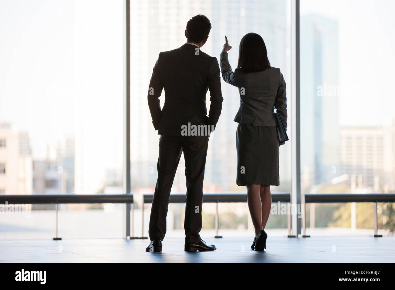 Business person looking through window Stock Photo - Alamy