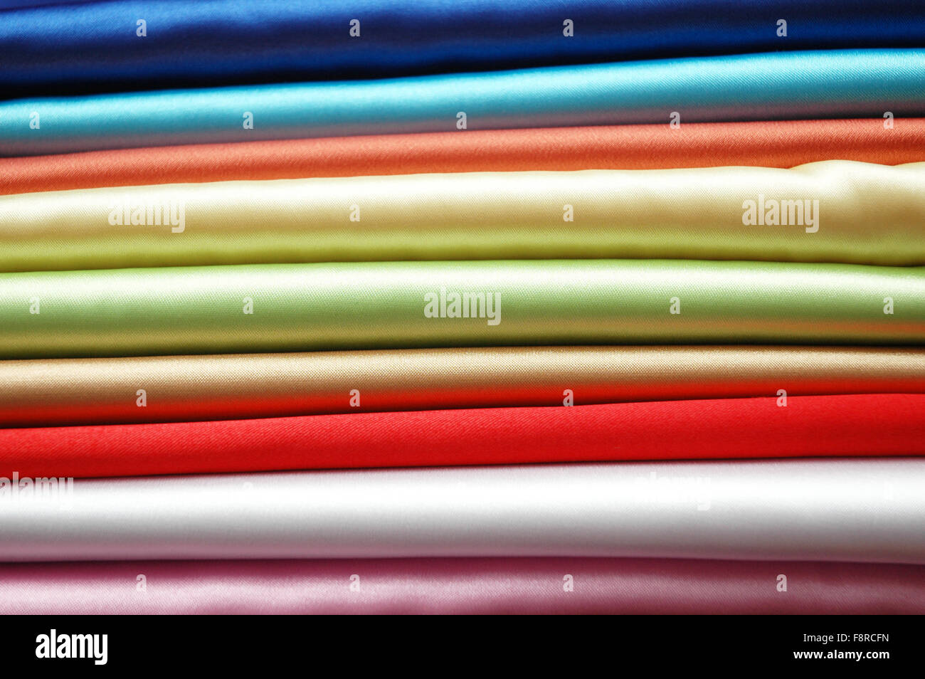 Stack of satin fabric of various colours Stock Photo - Alamy