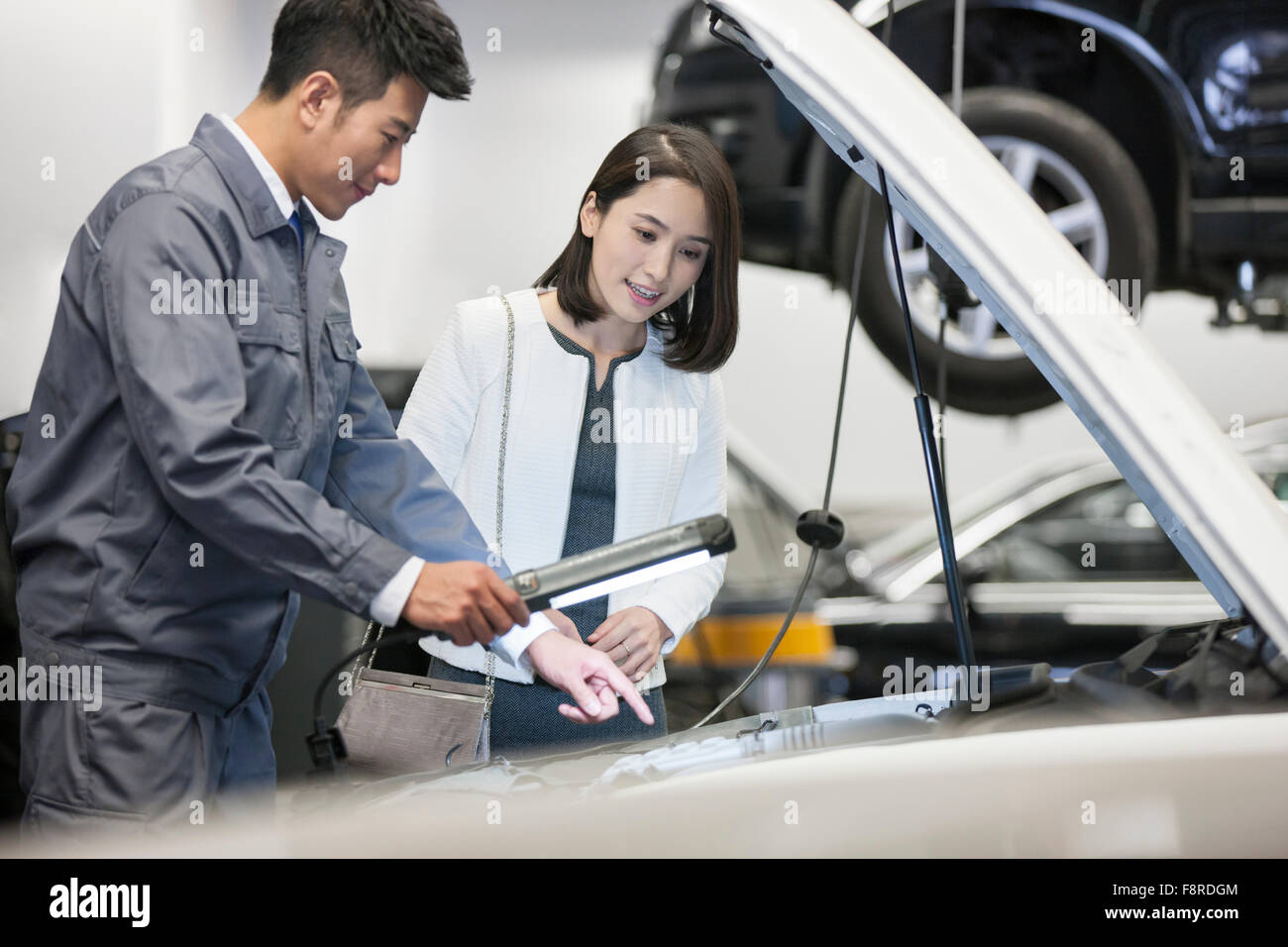 Auto mechanic talking with car owner Stock Photo - Alamy