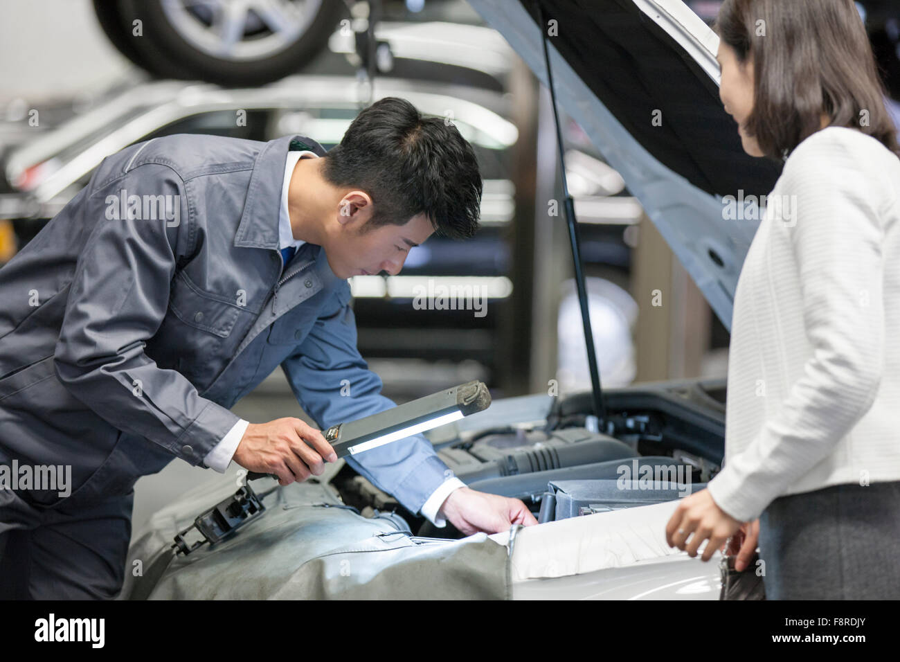 Auto mechanic talking with car owner Stock Photo - Alamy