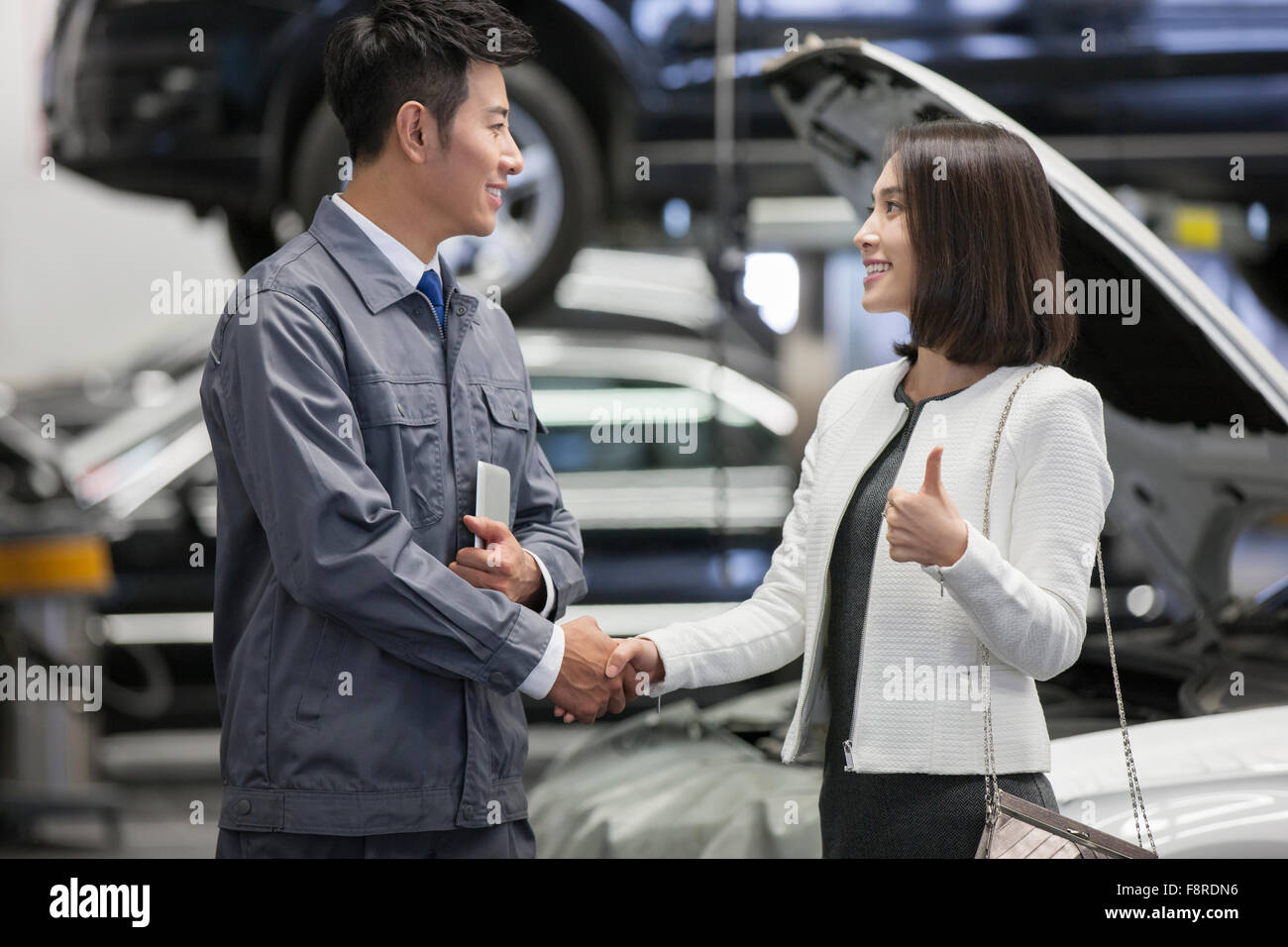 Auto mechanic and car owner shaking hands Stock Photo - Alamy