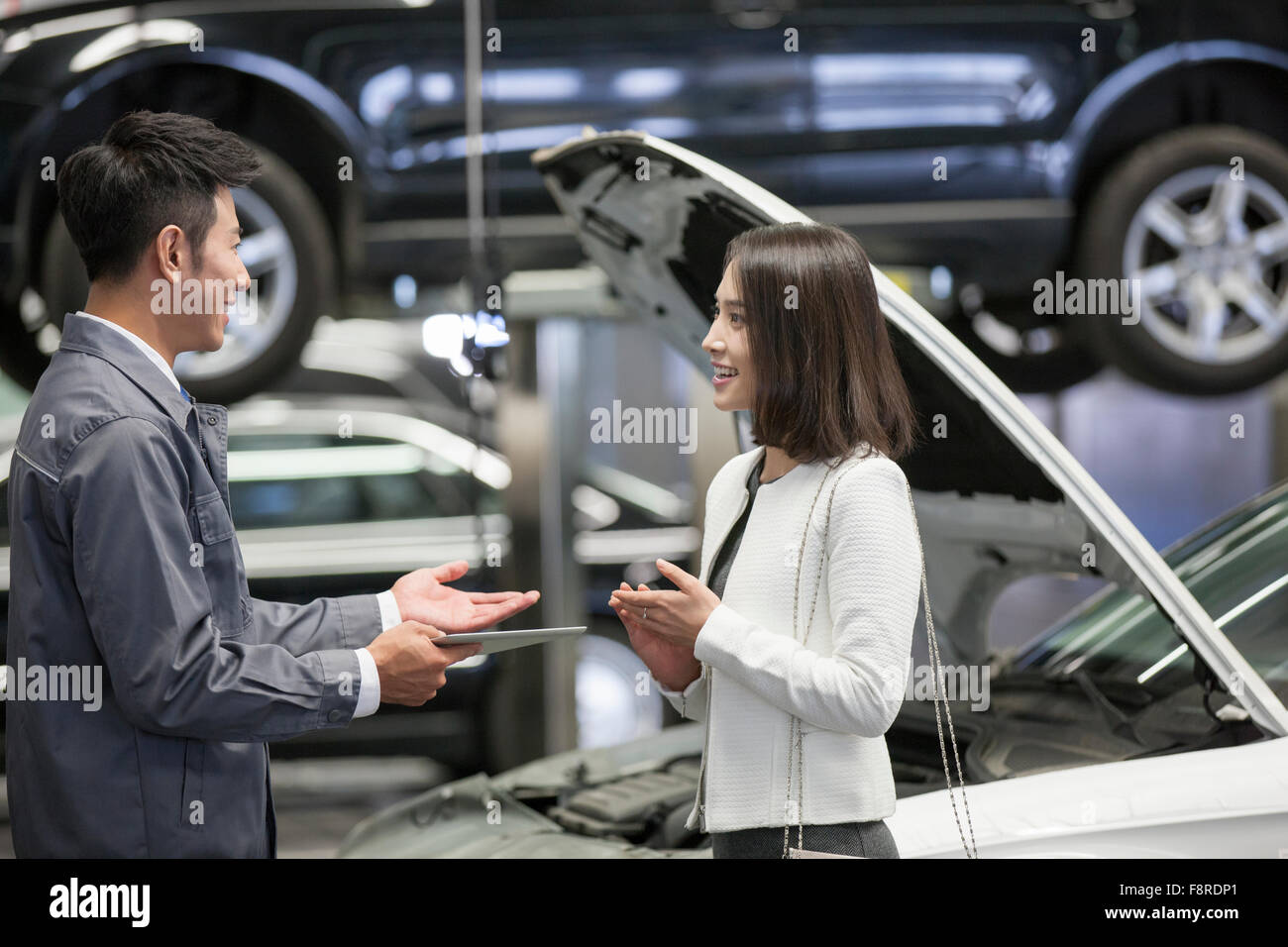 Auto mechanic talking with car owner Stock Photo - Alamy