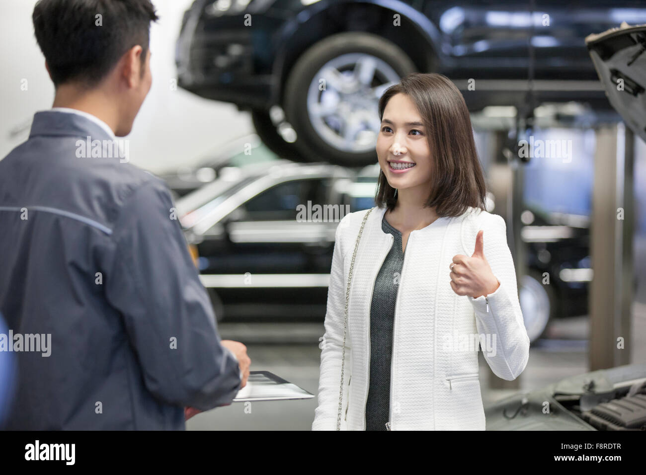 Auto mechanic talking with car owner Stock Photo - Alamy