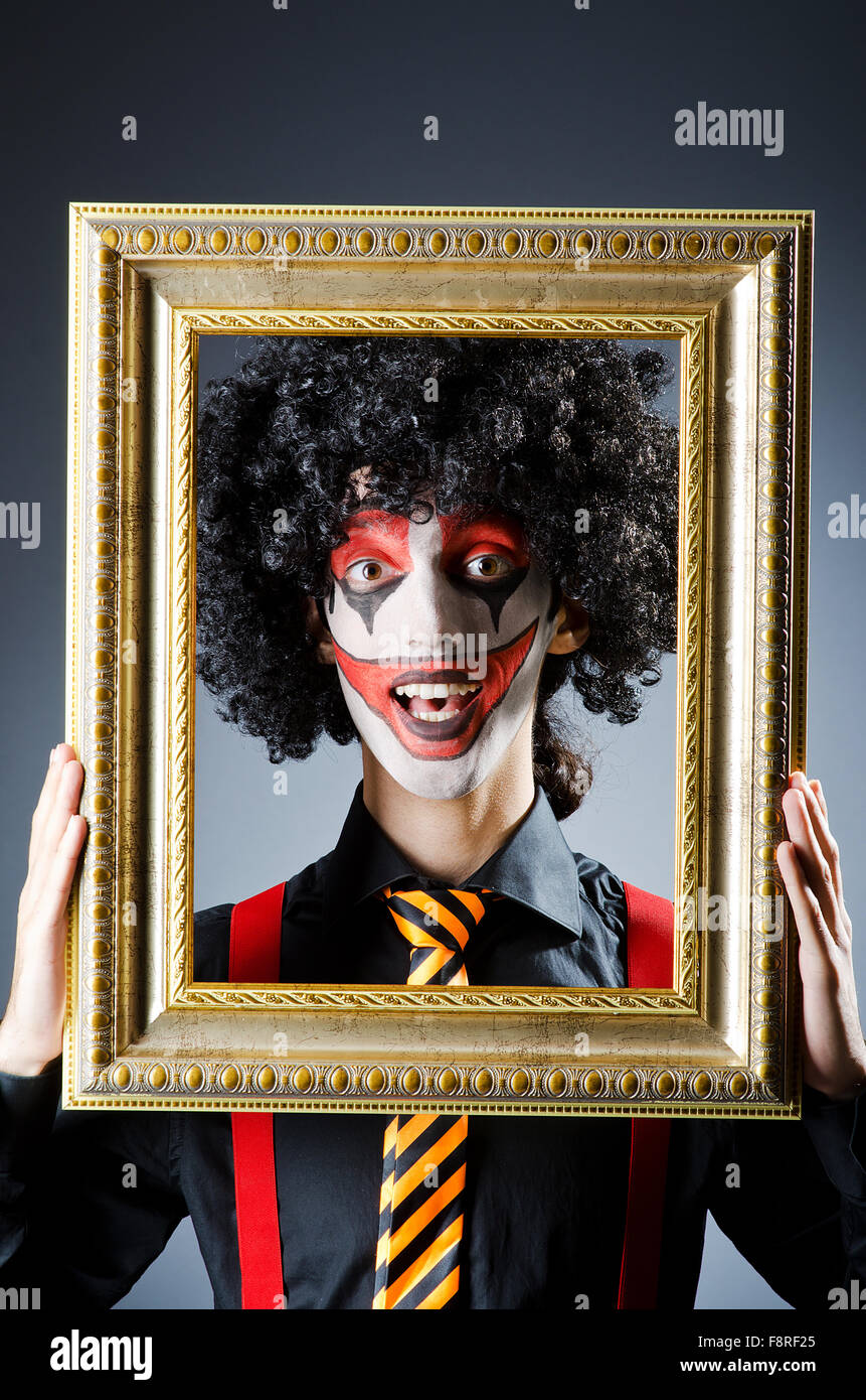Clown with picture frames in studio Stock Photo - Alamy