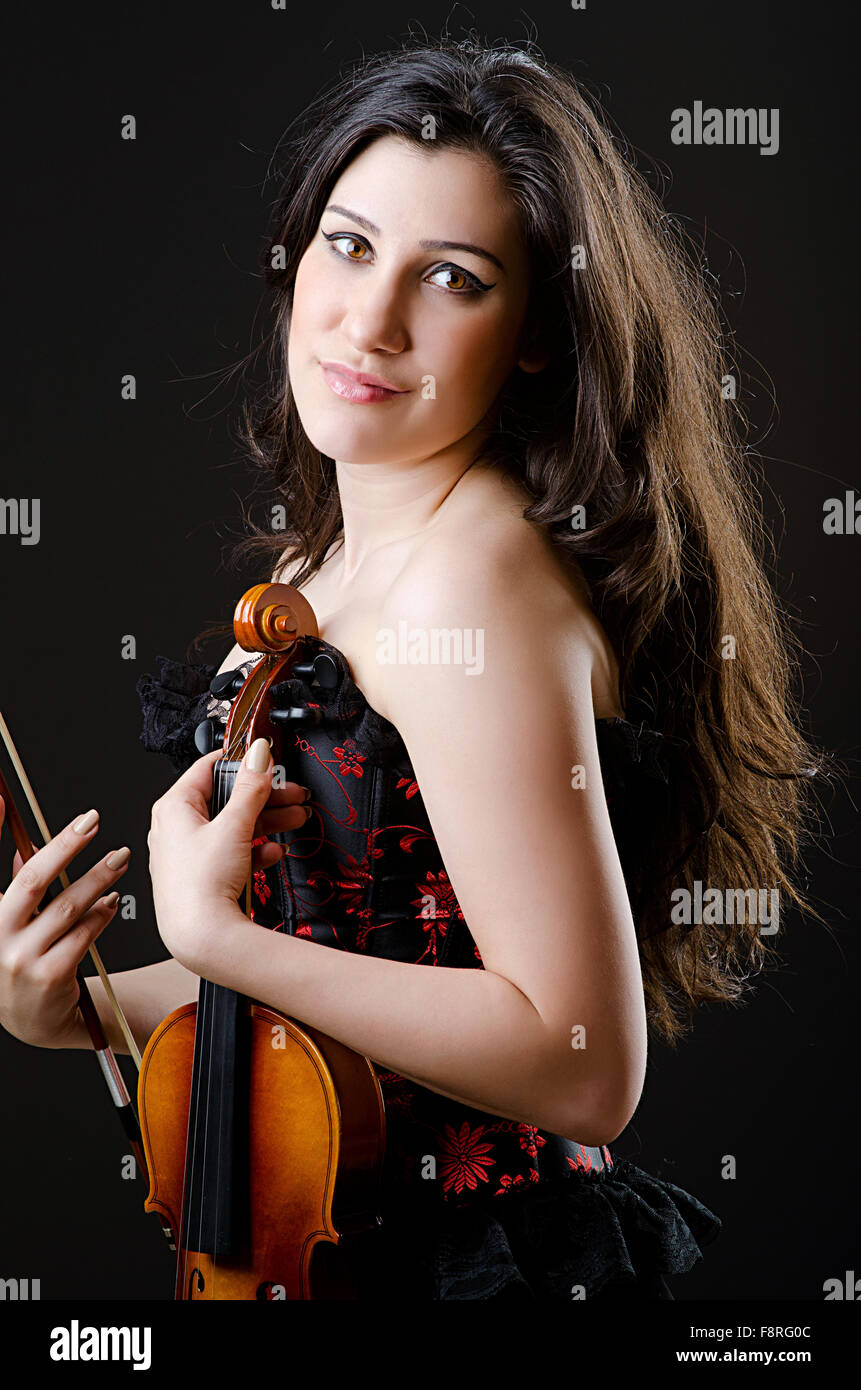 Female violin player against background Stock Photo - Alamy