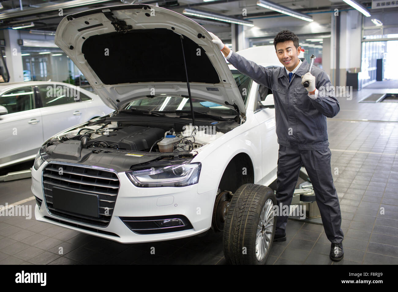 Standing holding work tool auto repair shop transportation industry hi ...