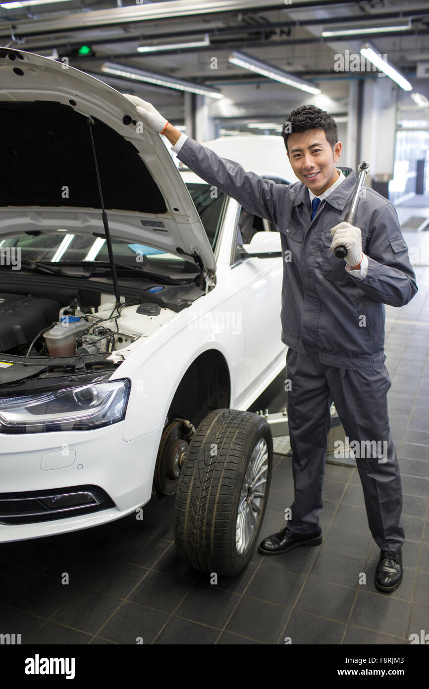 Standing holding work tool auto repair shop transportation industry hi ...