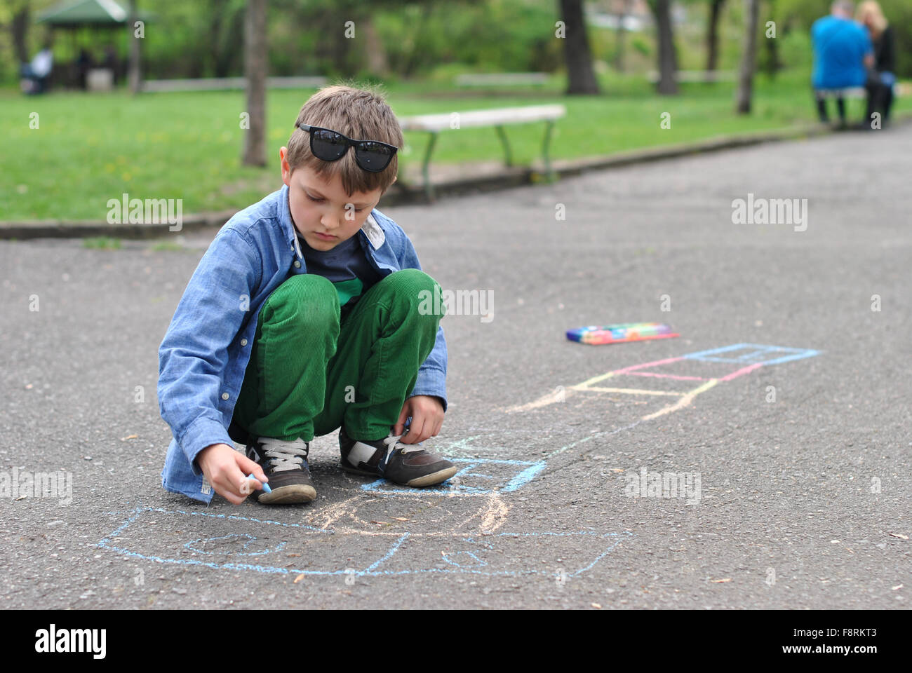 Boy drawing hopscotch on road with chalk Stock Photo - Alamy