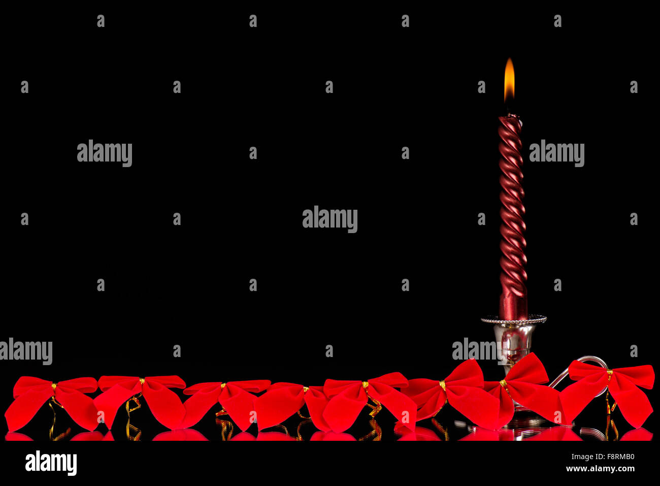 one red spiral candles in silver candlesticks, glass red ball in front ...