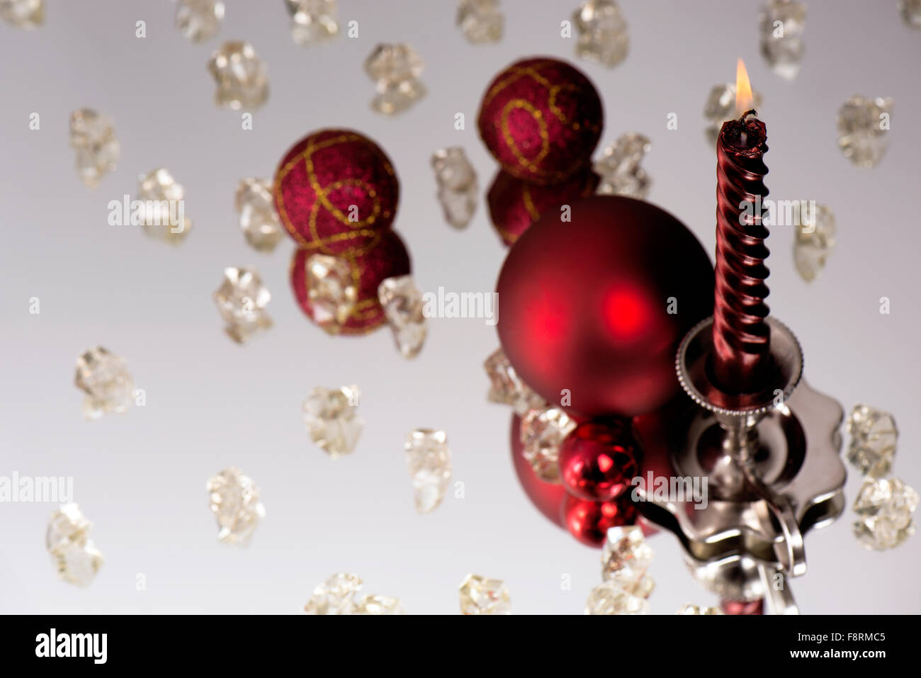 one red spiral candles in silver candlesticks, four red balls and ...