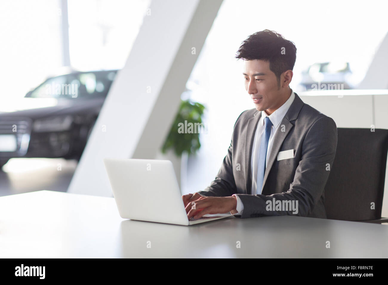 Car salesman working with laptop Stock Photo - Alamy