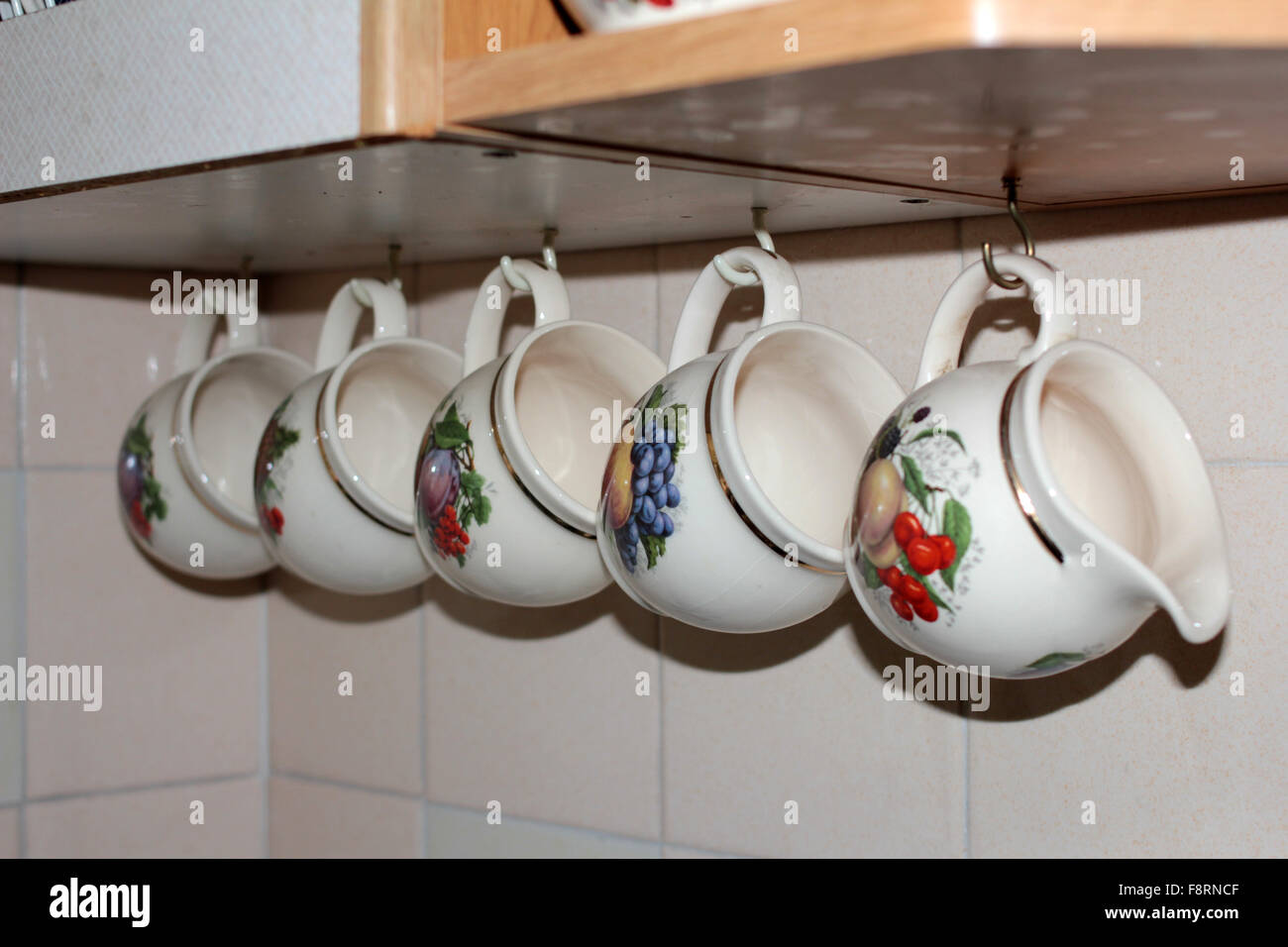 Hanging decorative cups and milk jug Stock Photo - Alamy