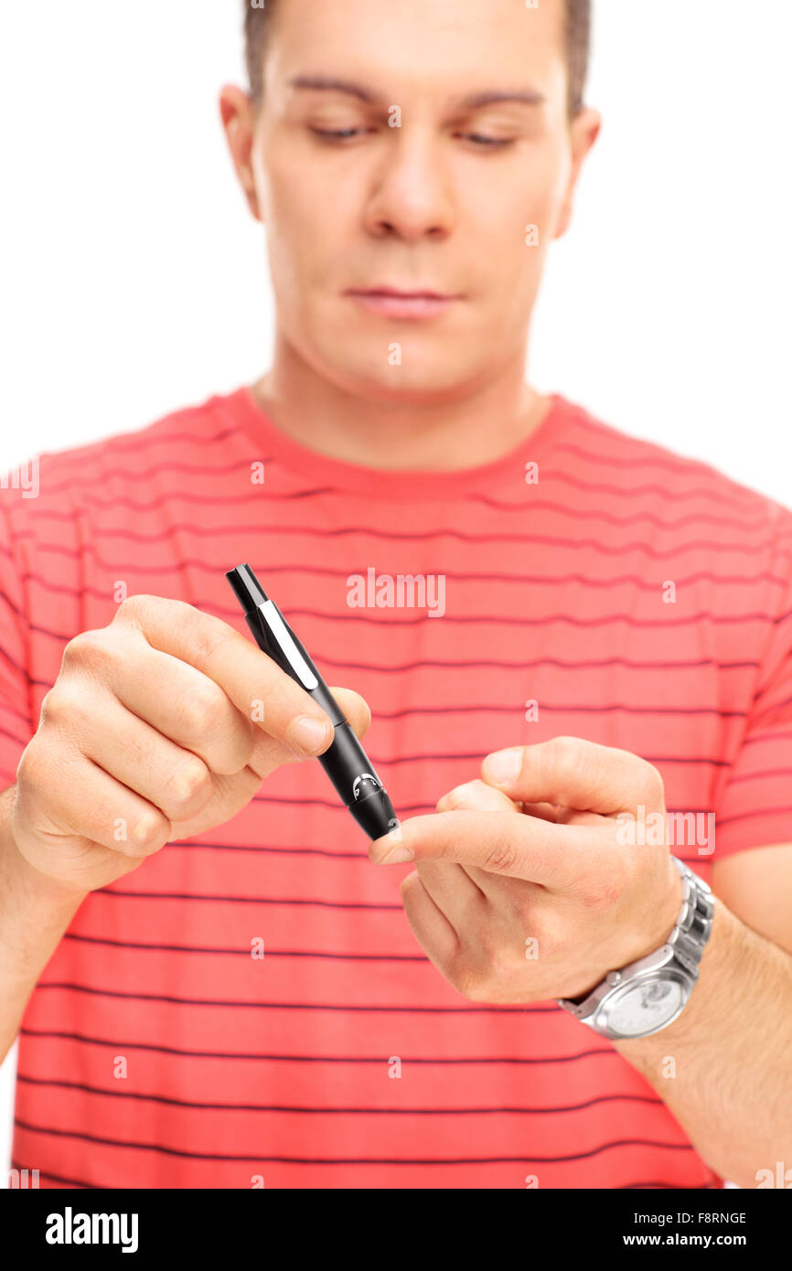 Vertical shot of a young man taking a blood sample with a glucometer to ...