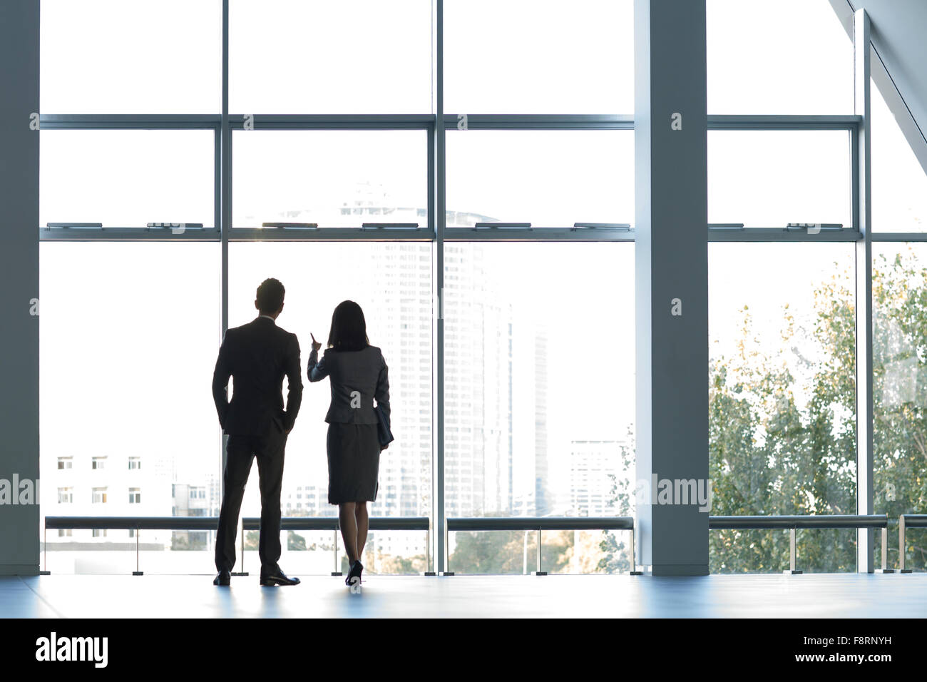Business person looking through window Stock Photo - Alamy