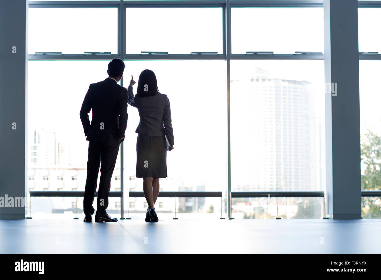 Business person looking through window Stock Photo - Alamy