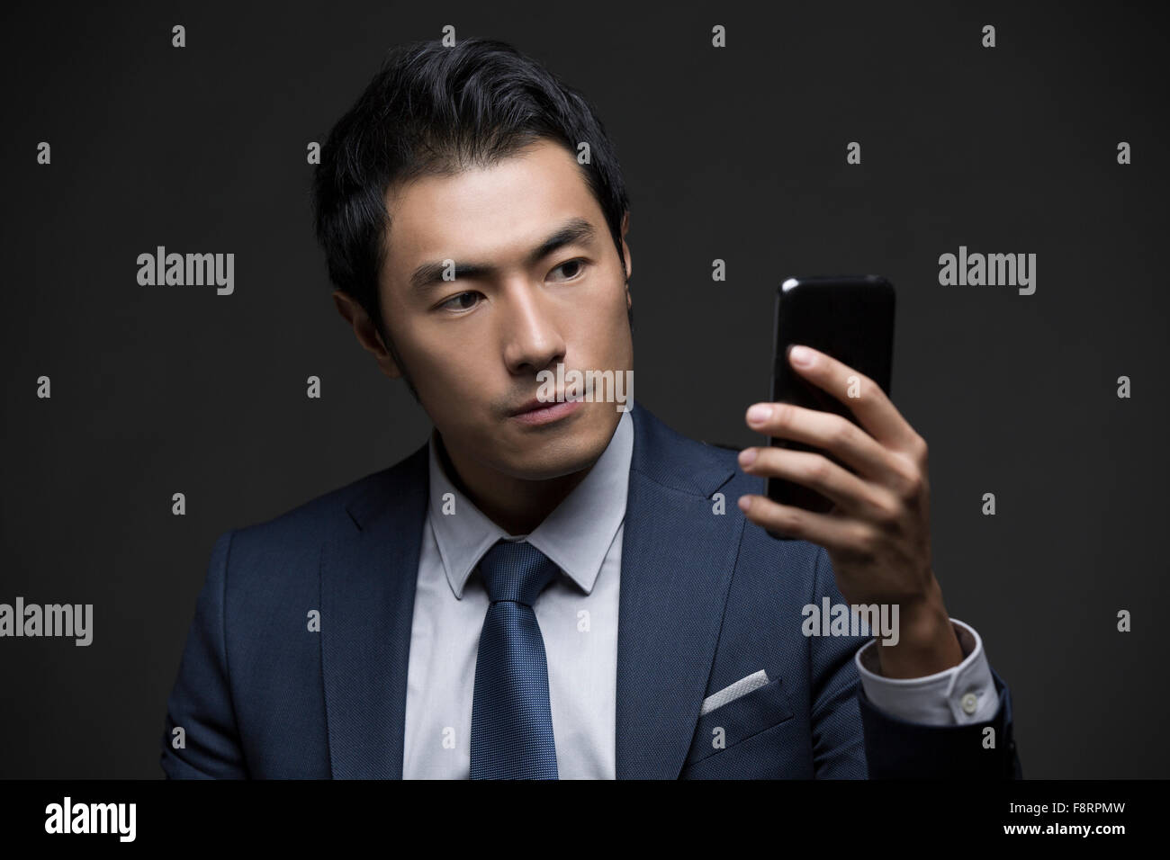 Confident businessman using smart phone Stock Photo - Alamy