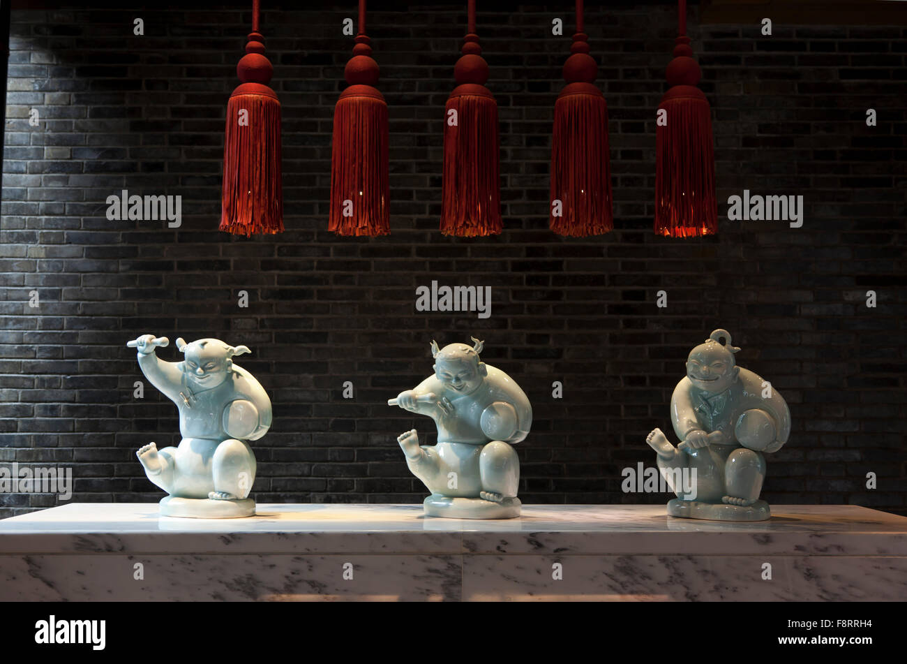 Three jade sculptures set on a stylish marble pedestal at the entrance ...
