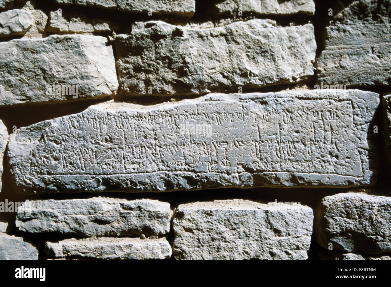 Inscription on a stone built in to a wall in the ancient town of Al ...