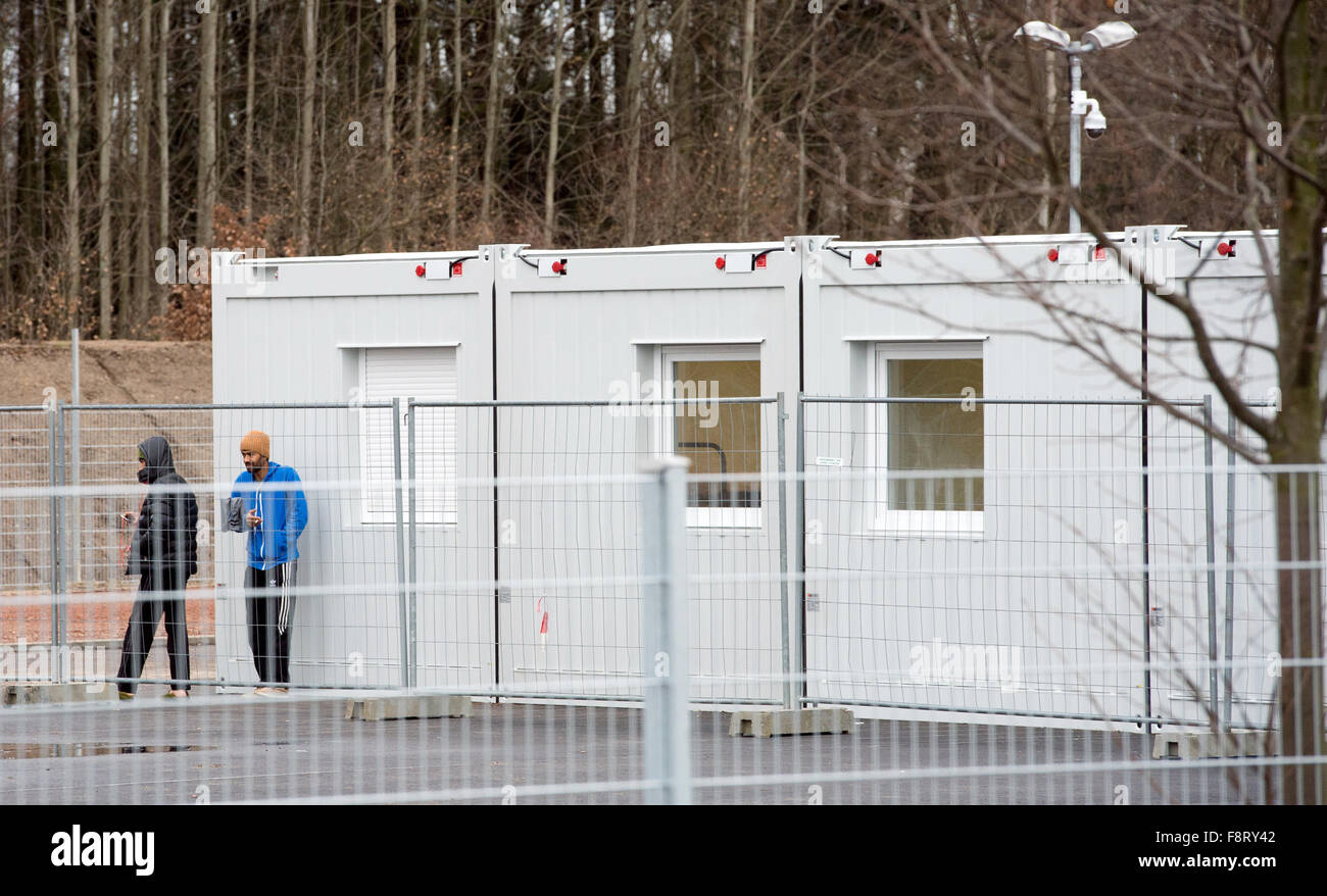 Refugees walking towards a container building on the grounds of refugee ...