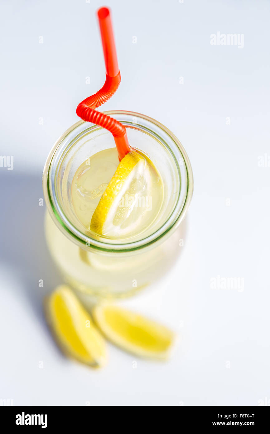Different tips of lemonade in the jug with straws and lemons on white ...