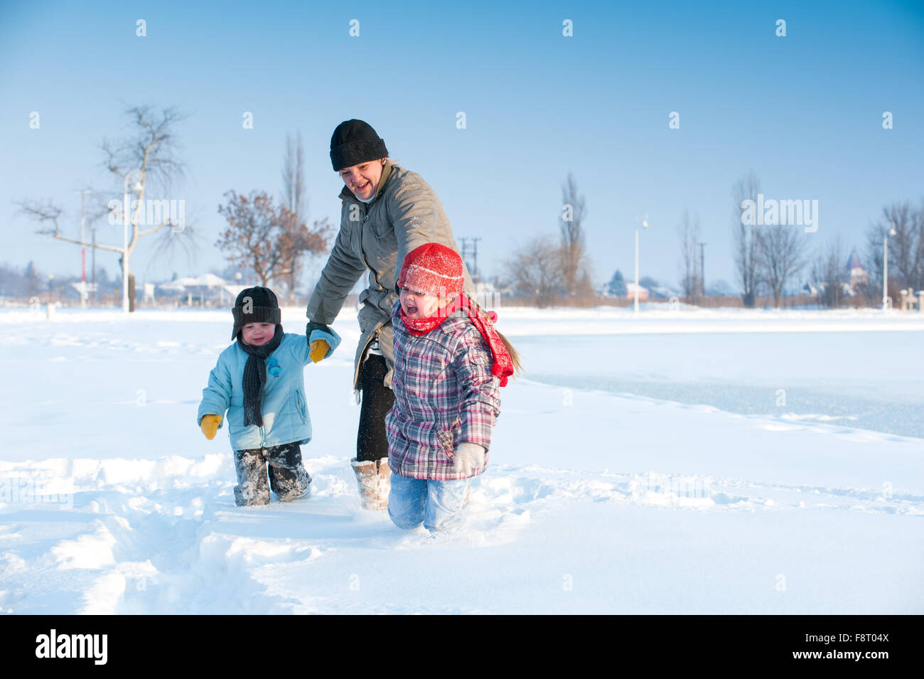 Mom, daughter and son running in the snow Stock Photo - Alamy