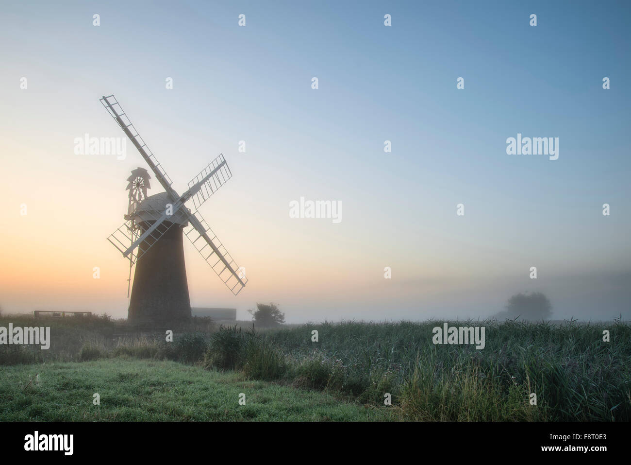 Windmill in stunning landscape on beautiful Summer sunrise Stock Photo ...