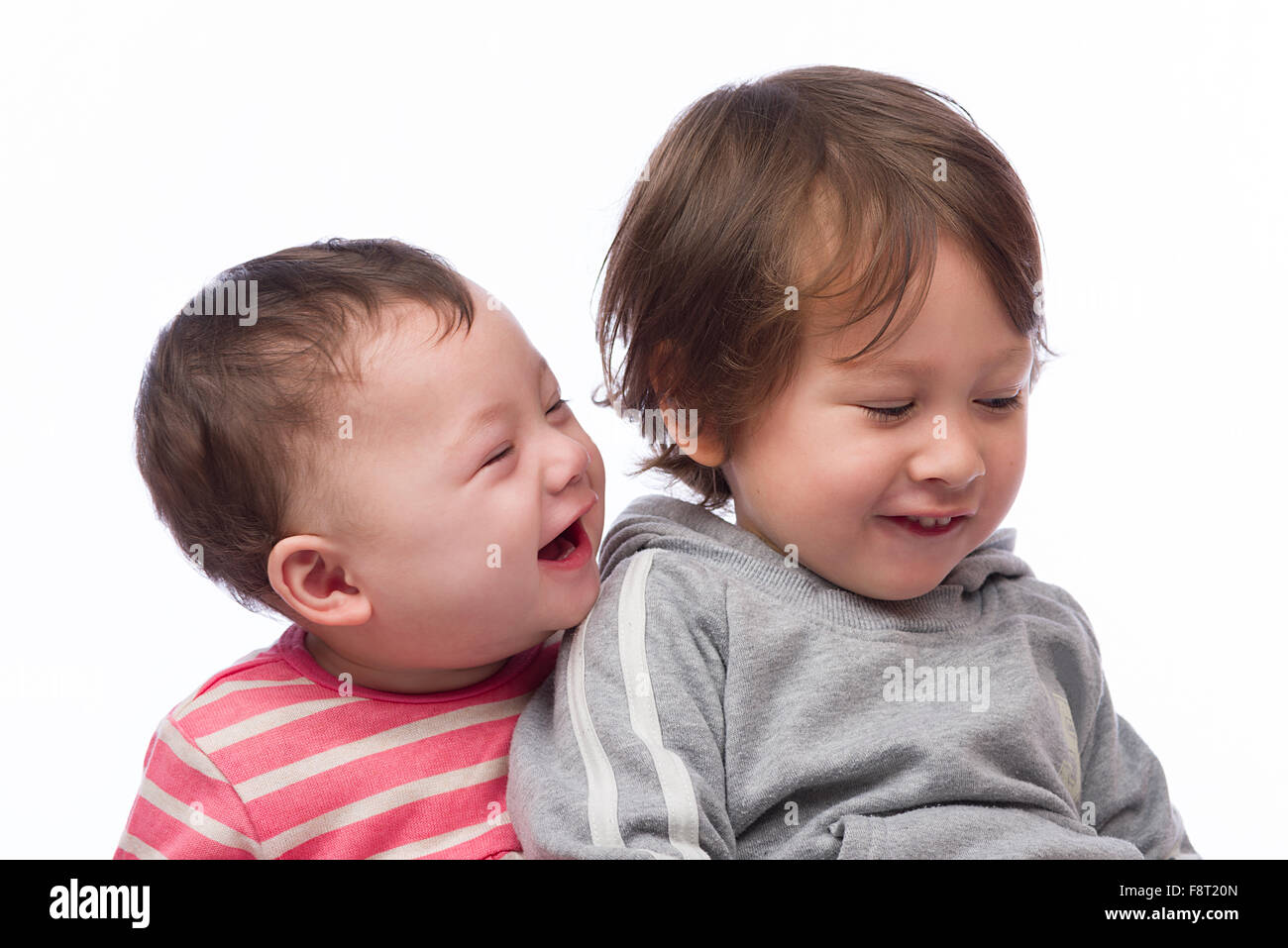 A portrait of a cute and loving brother and sister on a white ...