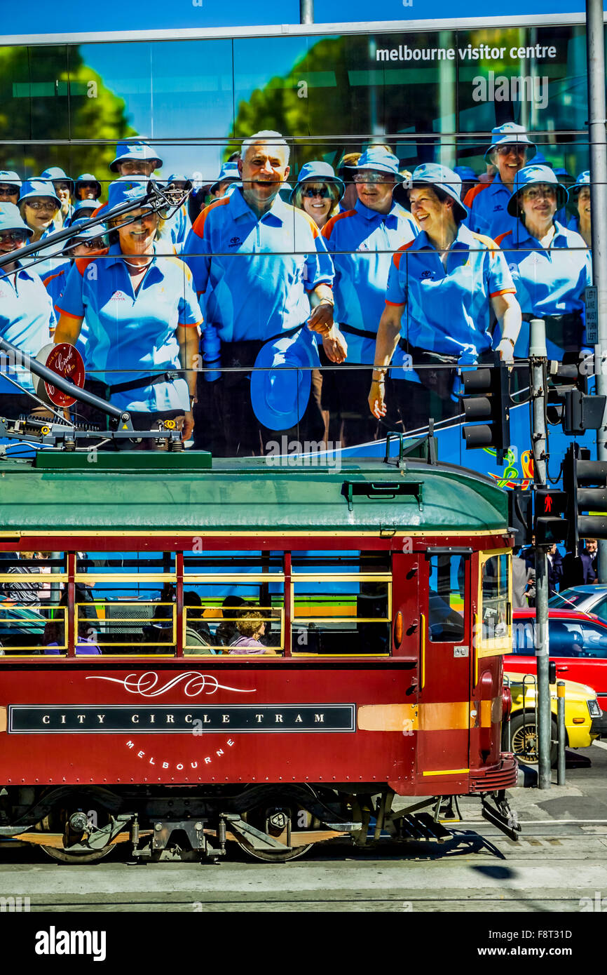 Red heritage tram travelling past Visitor Centre, Melbourne, Australia ...