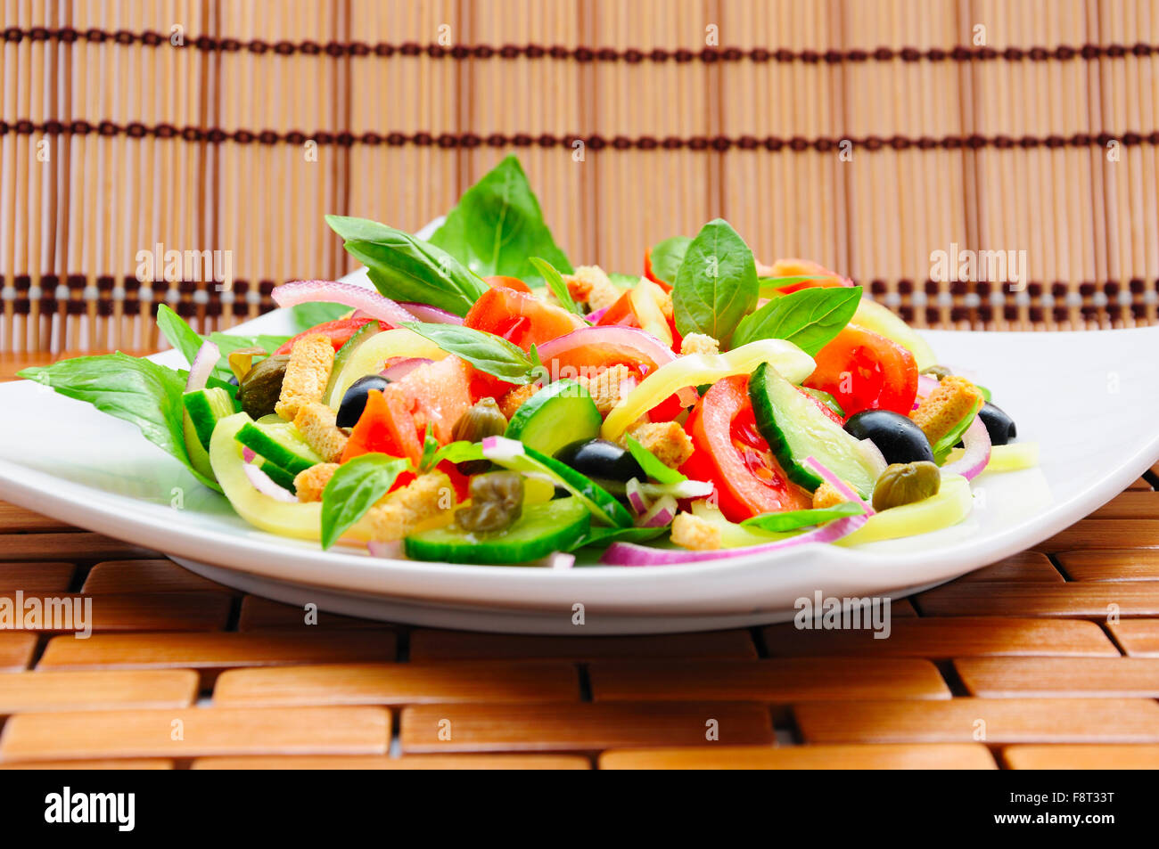 Fresh vegetable salad with basil, capers, olives, marinated with ...