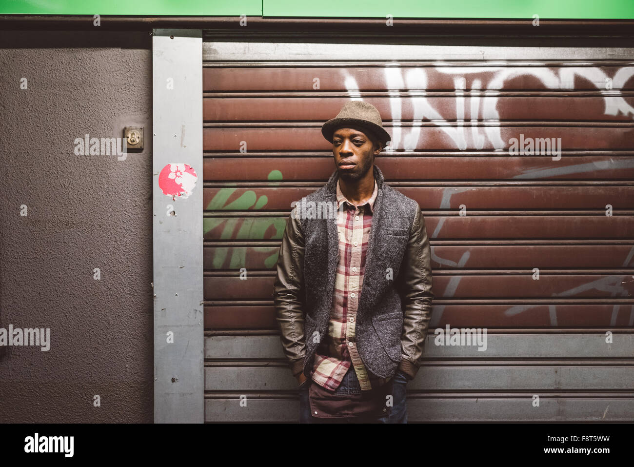 Knee figure of young handsome afro black man posing leaning against a ...