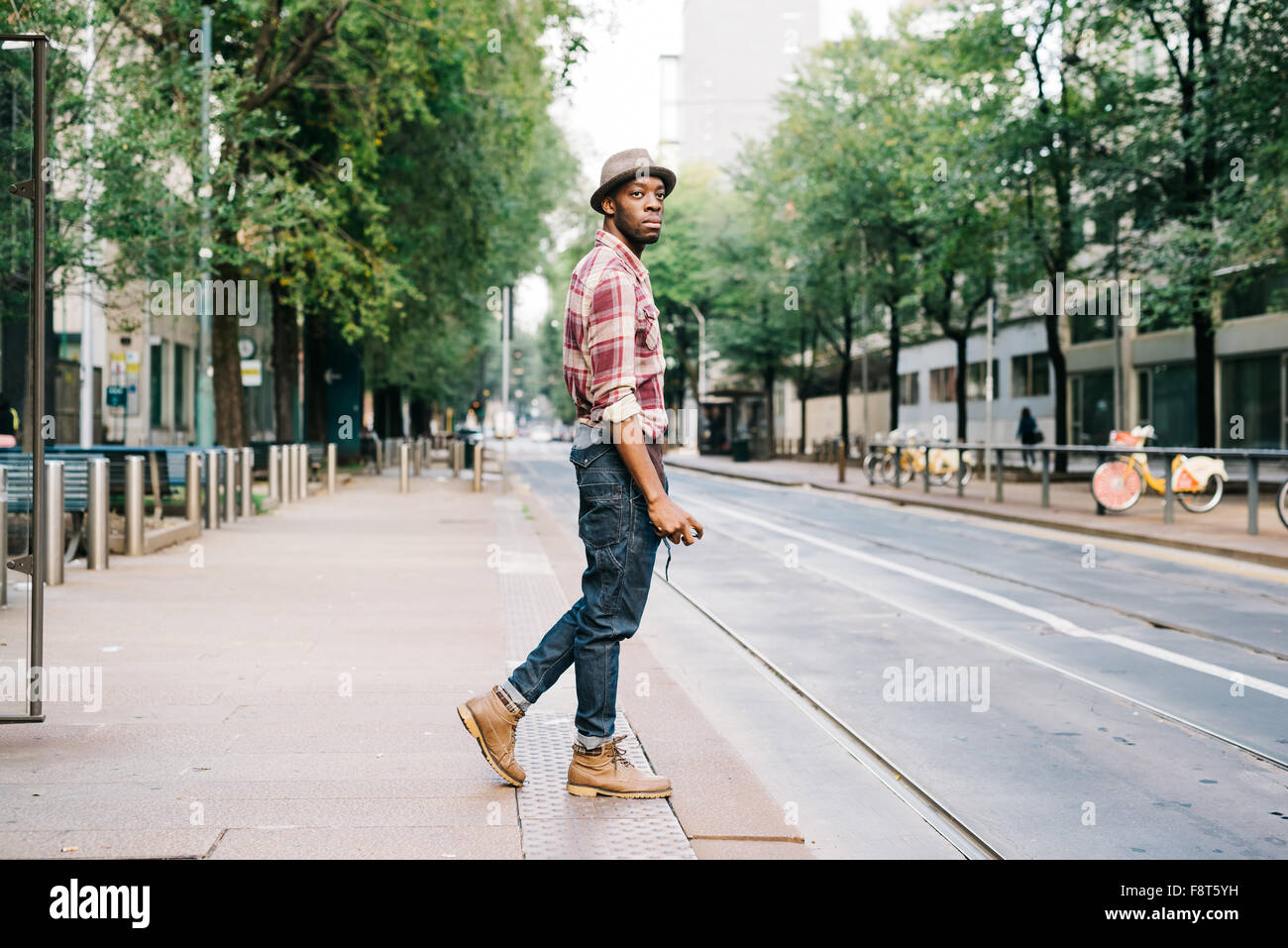 young handsome afro black man standing on the edge of the sidewalk, he ...