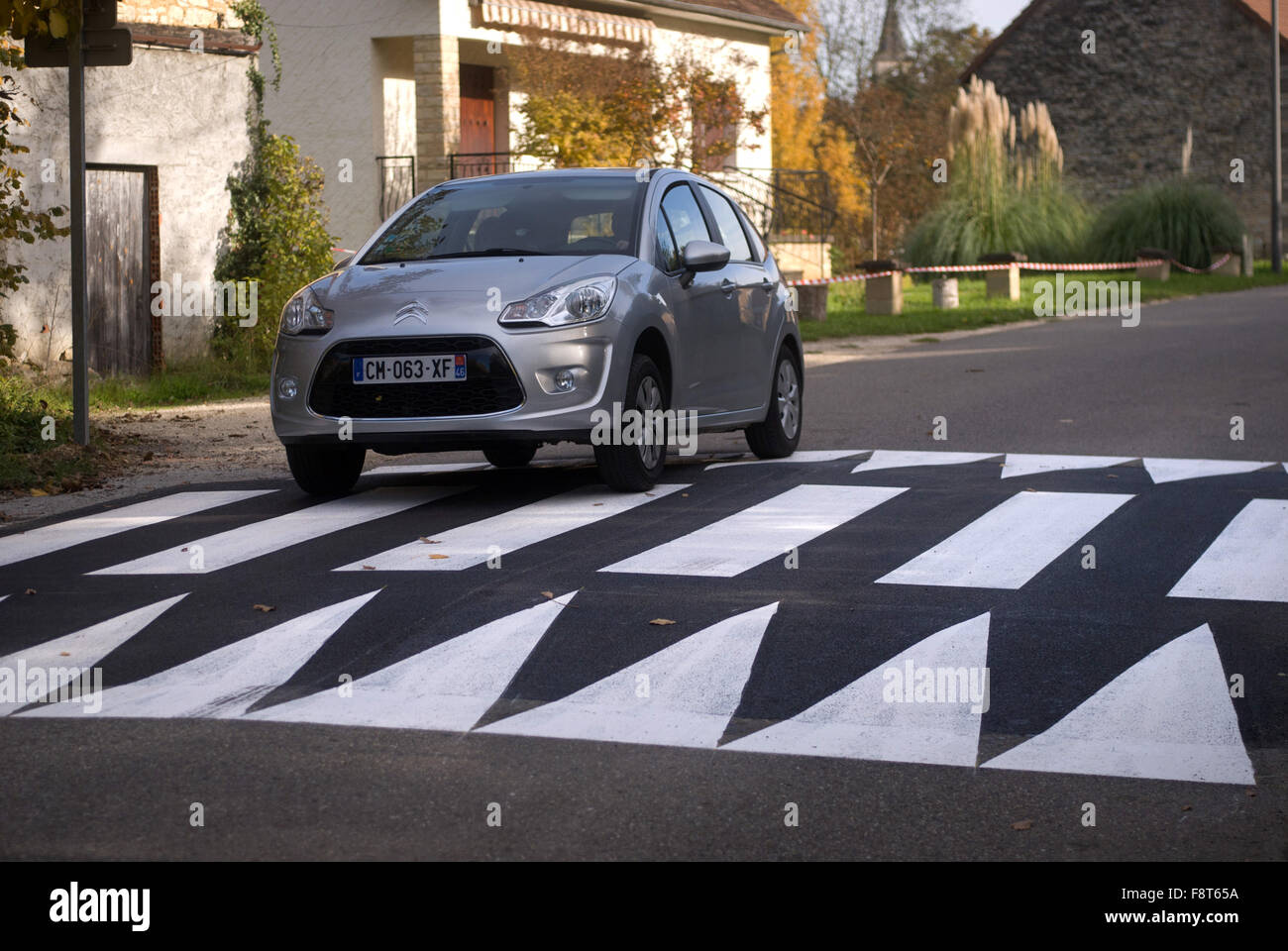 Car going over Speed bump / Sleeping policeman, France Stock Photo - Alamy