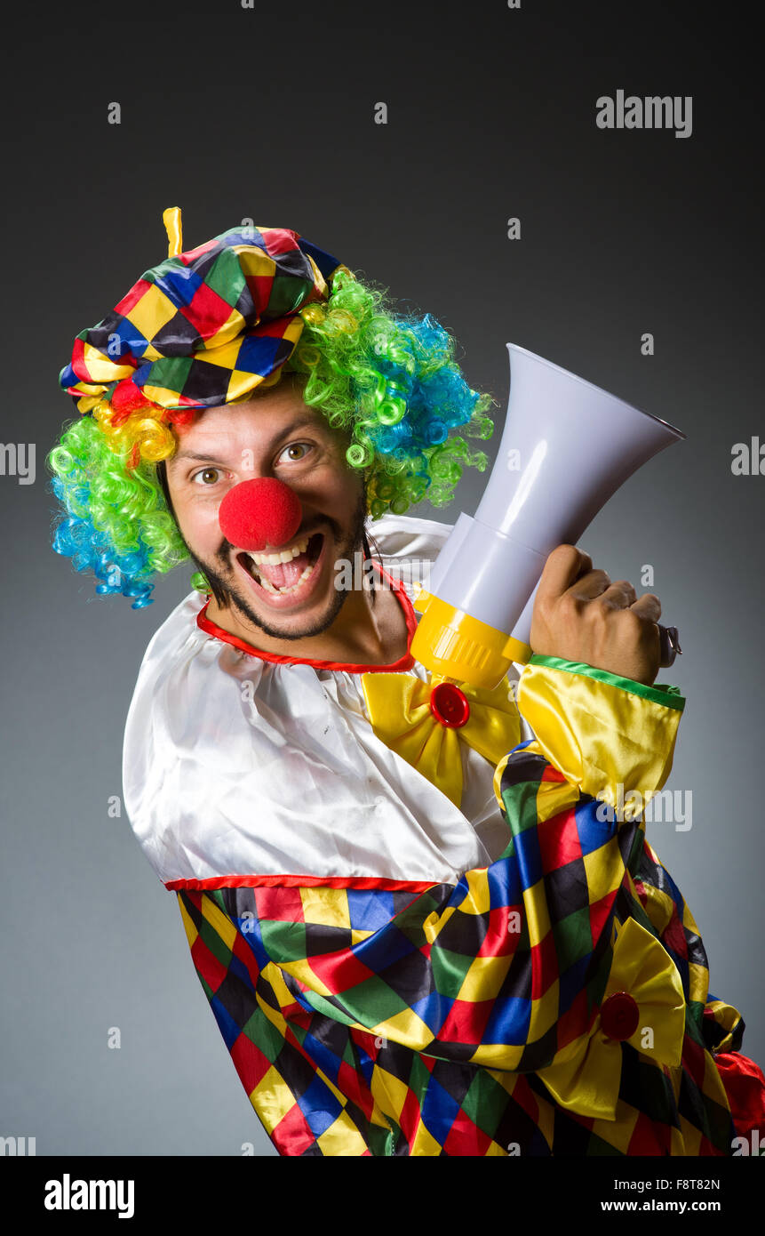 Clown with loudspealer against curtain Stock Photo - Alamy