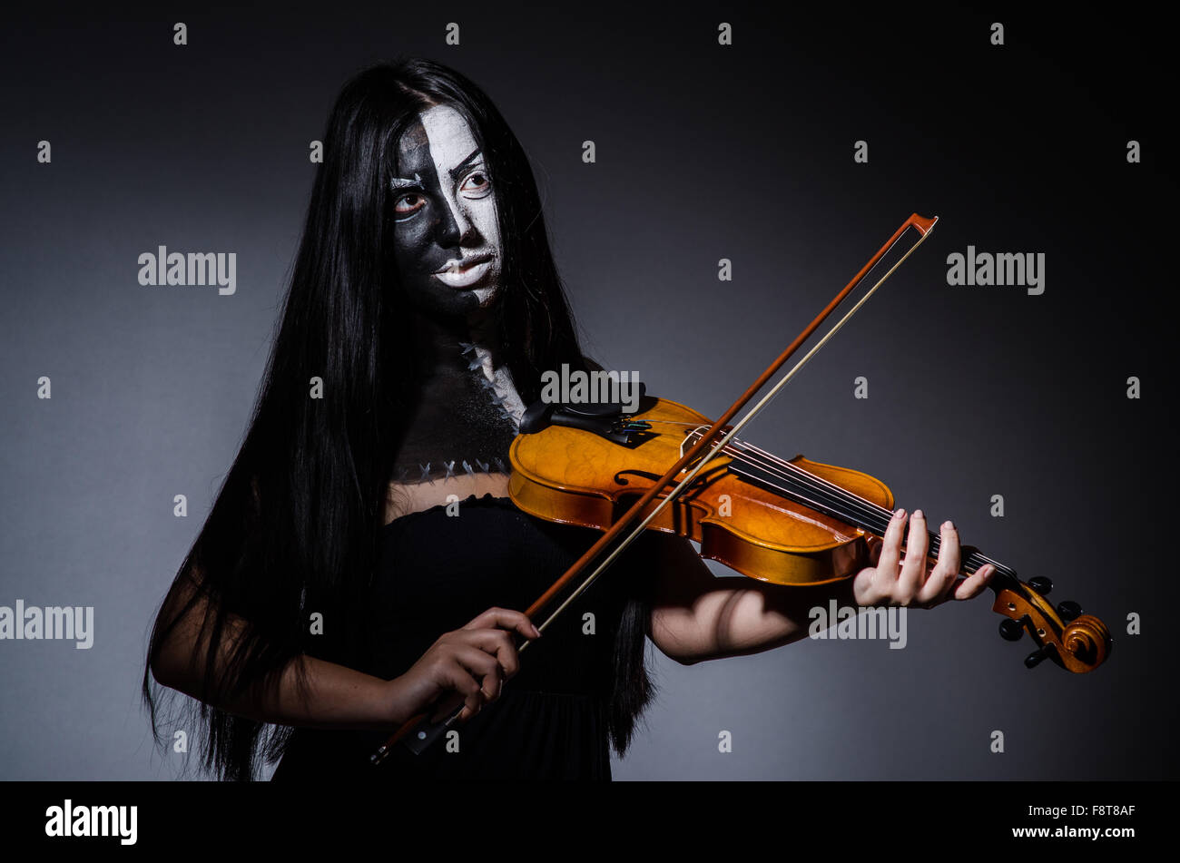 Scary monster playing violing in halloween concept Stock Photo - Alamy